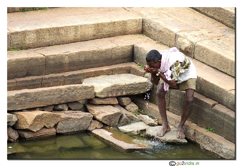 go2india.in : person drinking water in a spoiled pond